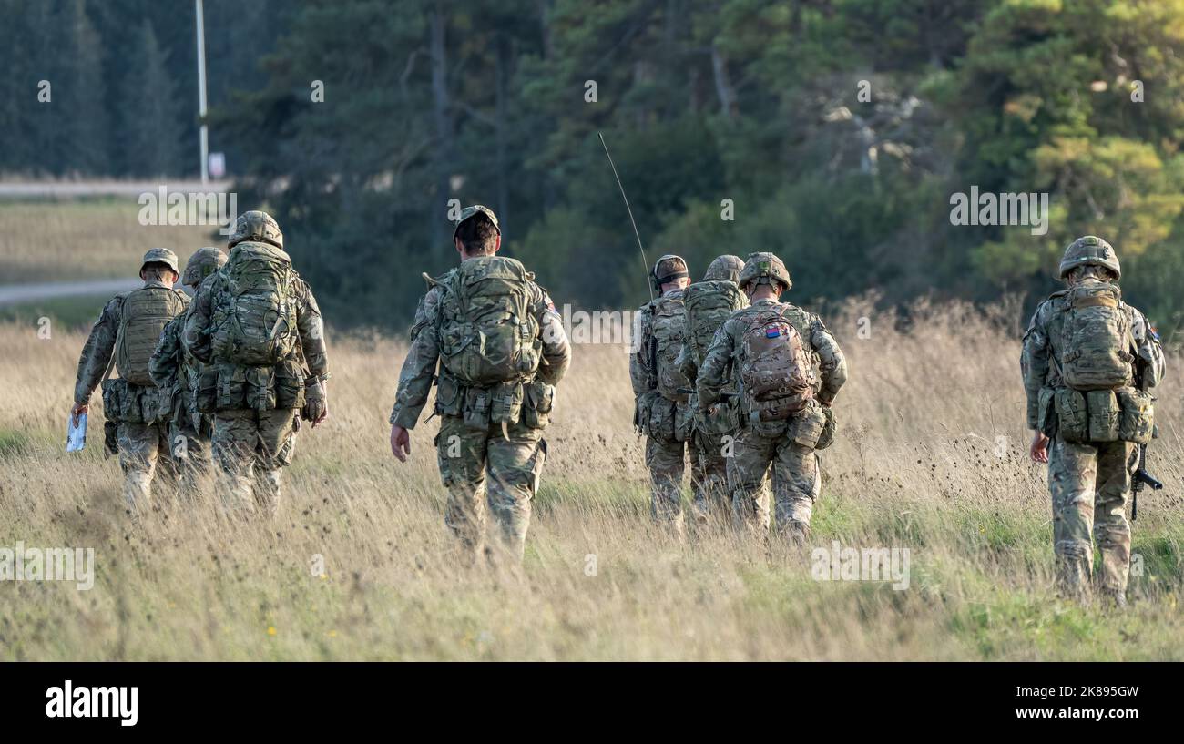 8 British army soldiers tabbing with 25Kg bergens across open ...