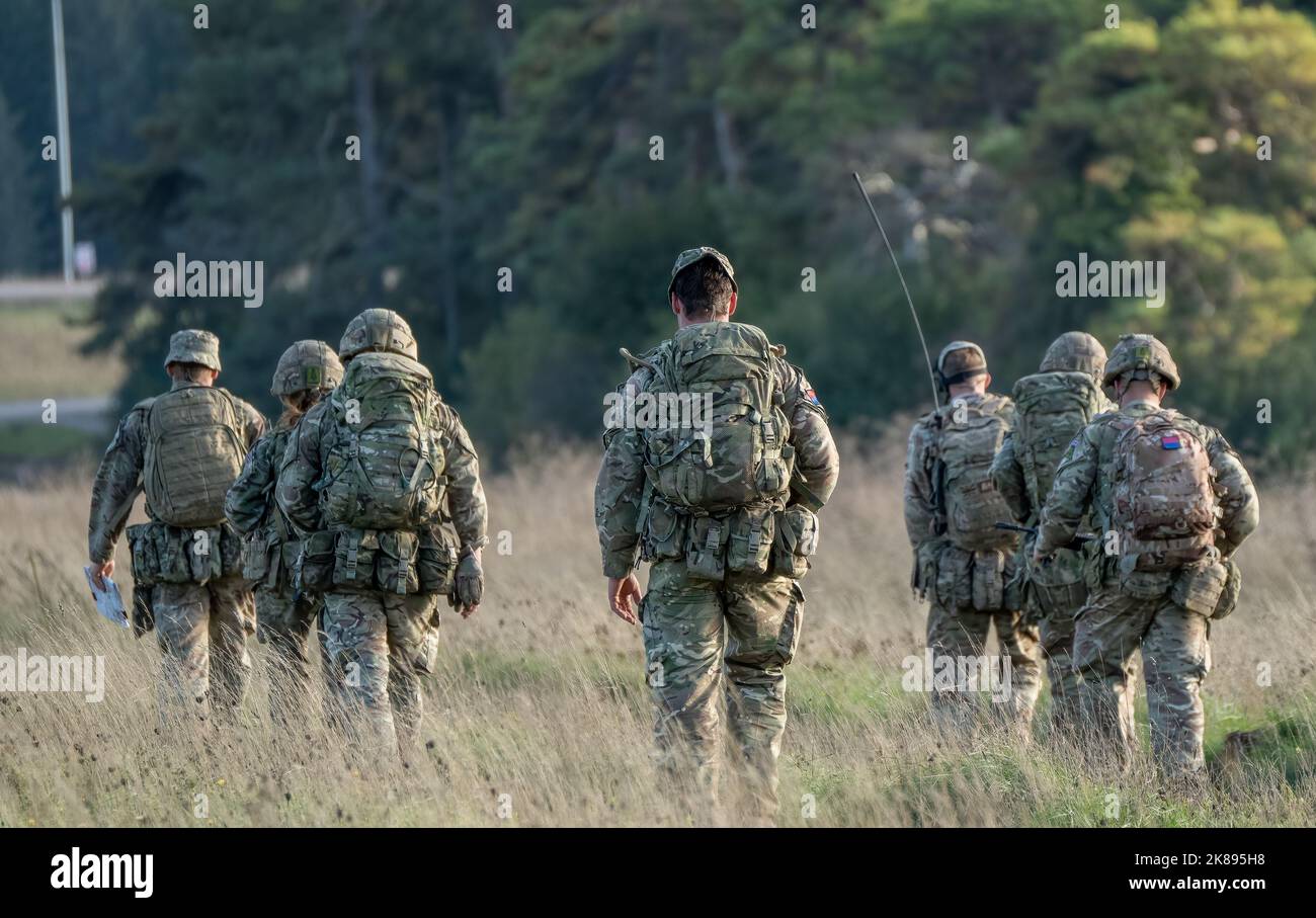 8 British army soldiers tabbing with 25Kg bergens across open ...