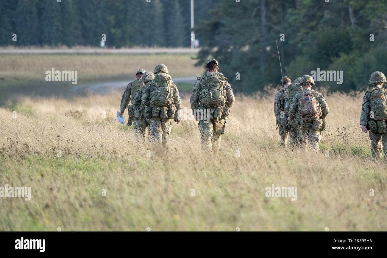8 British army soldiers tabbing with 25Kg bergens across open ...