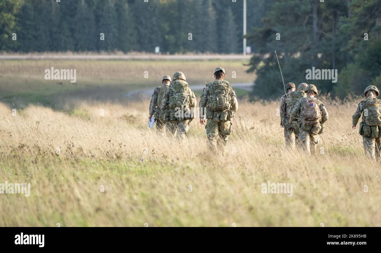 8 British army soldiers tabbing with 25Kg bergens across open ...