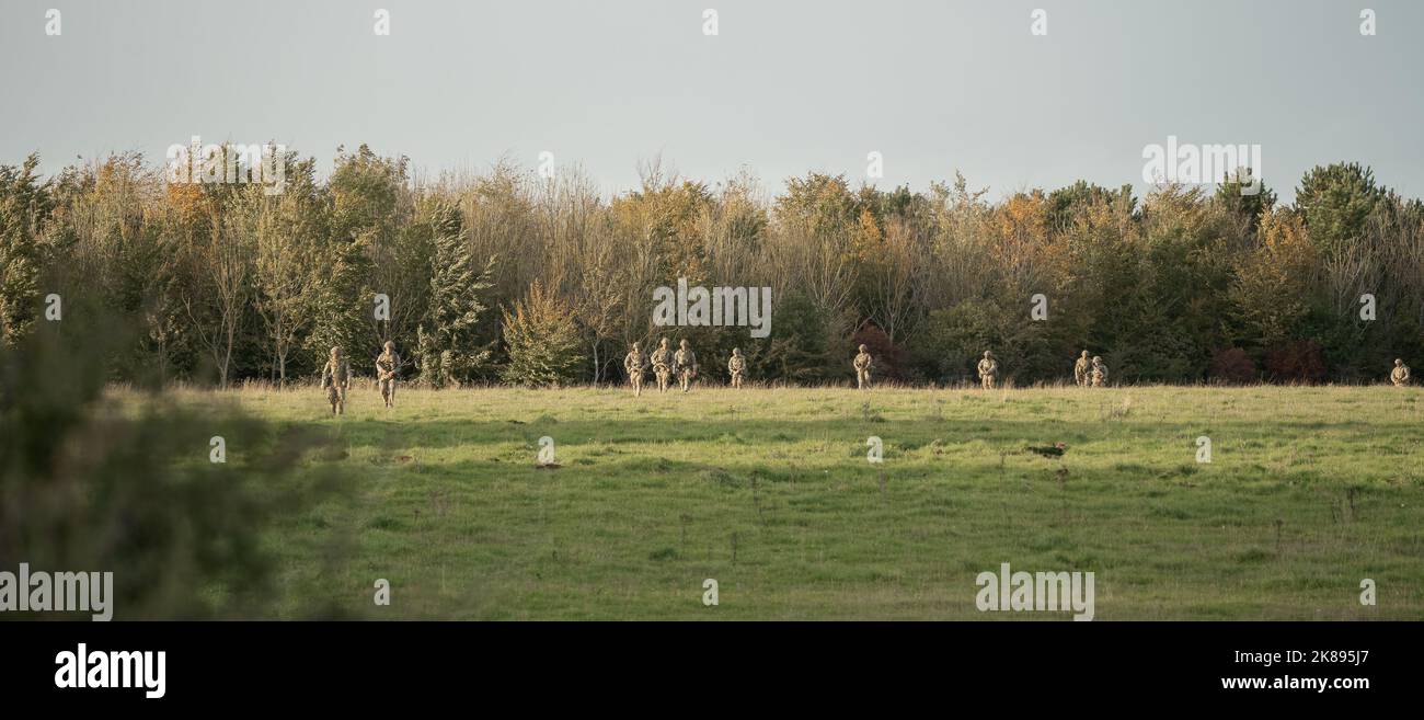 British army soldiers crossing open ground, weapons ready on a military ...