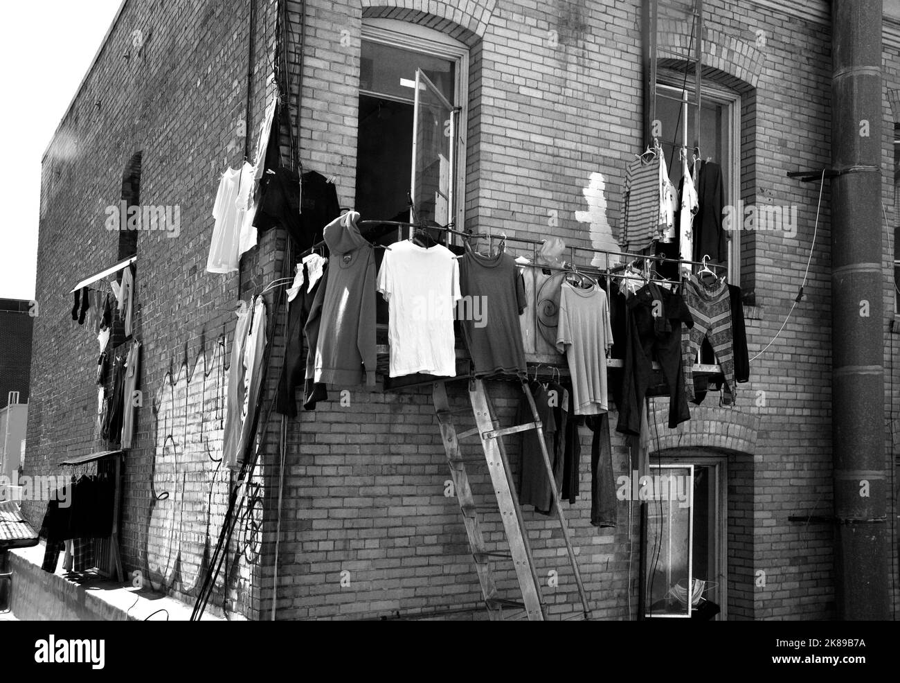 Washed clothing hanging to dry in the sun on a low-income residential ...