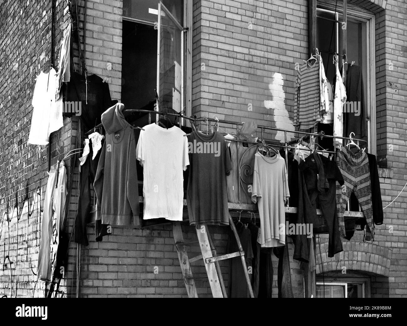 Washed clothing hanging to dry in the sun on a low-income residential ...