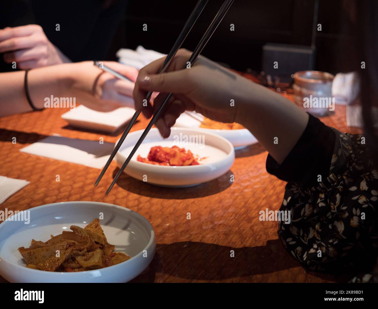 Hands picking at side dishes in a Korean restaurant Stock Photo - Alamy