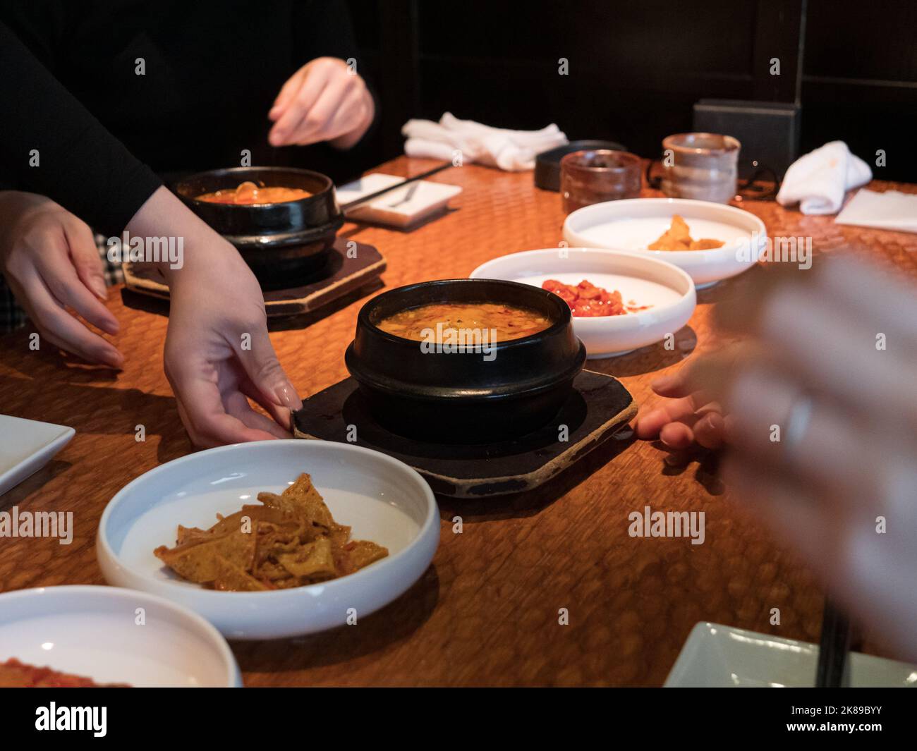 Hands picking at side dishes in a Korean restaurant Stock Photo - Alamy