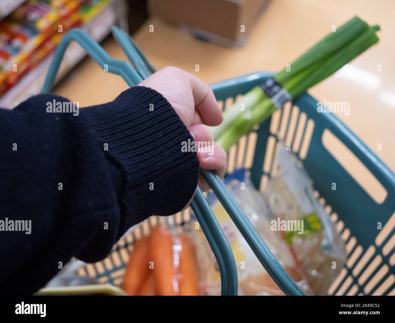 A young man's hand holding a shopping basket Stock Photo - Alamy