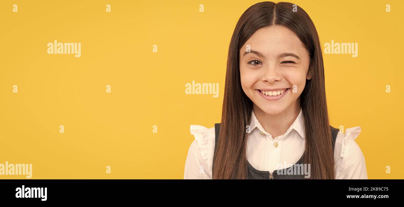 Happy school age girl child with smiling face give wink yellow ...