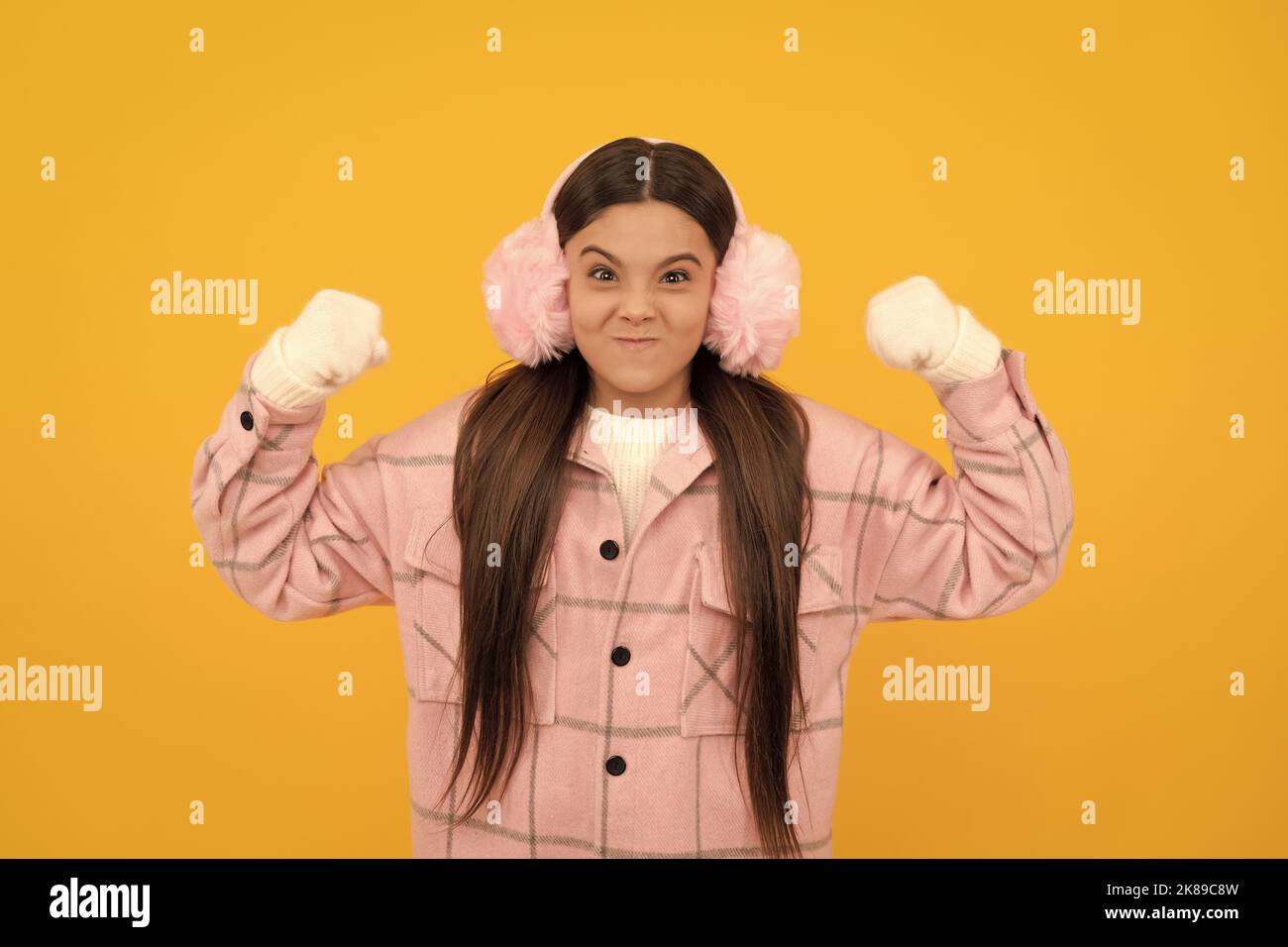 express emotion. winter fashion. angry kid in fur earmuffs showing ...