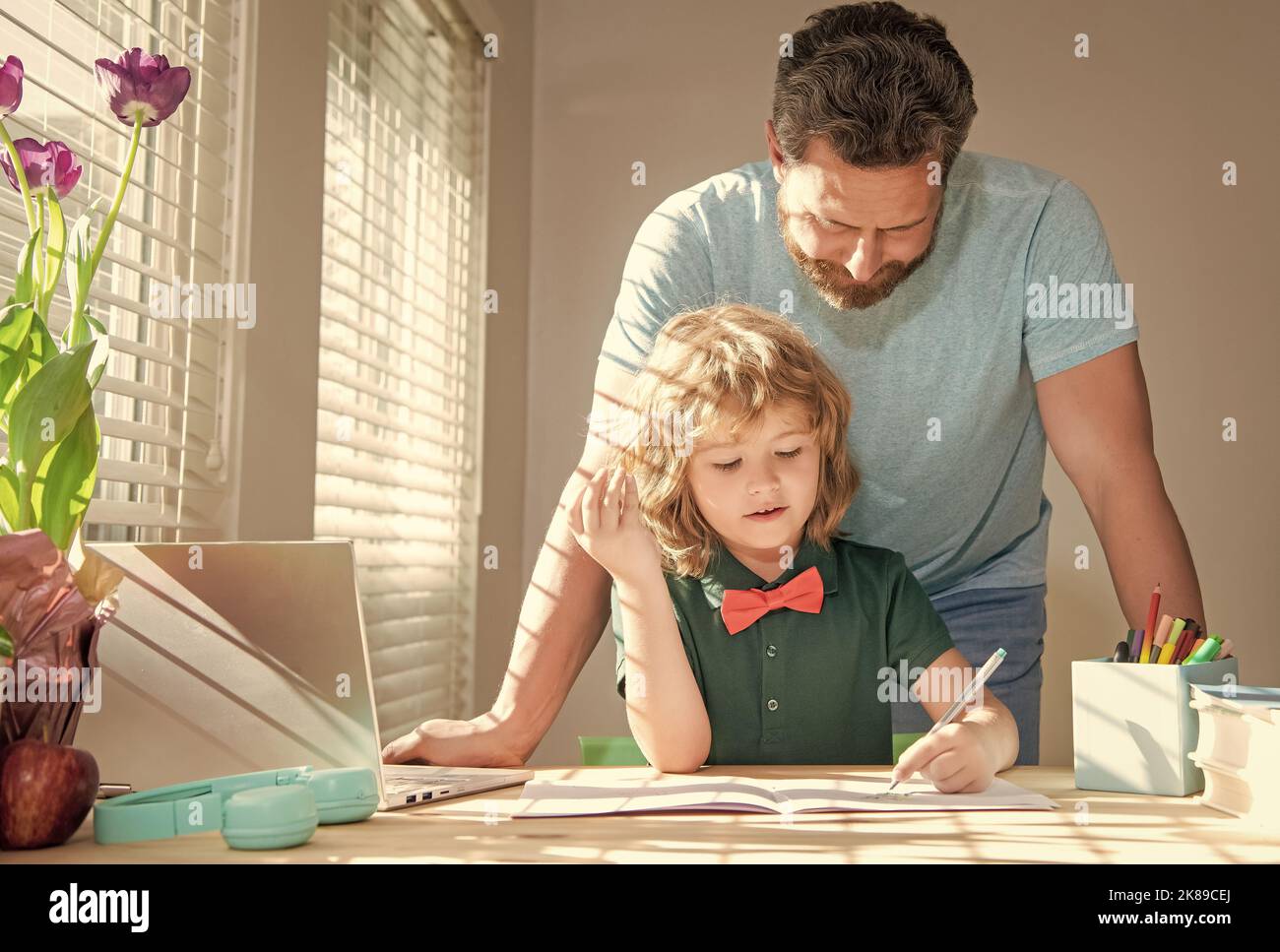 bearded dad writing school homework with his kid son in classroom ...