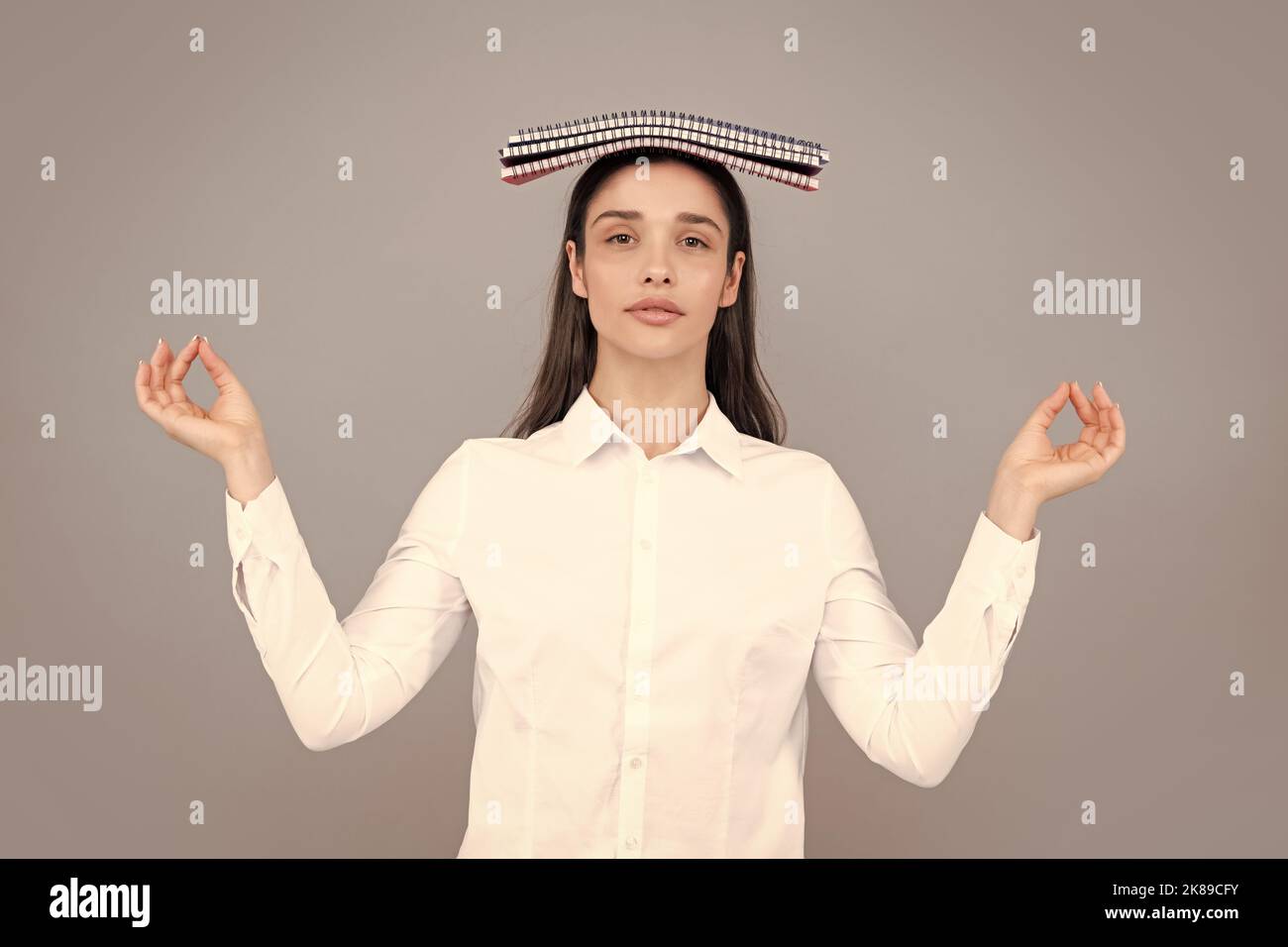 Female student holds books isolated on gray background in studio ...