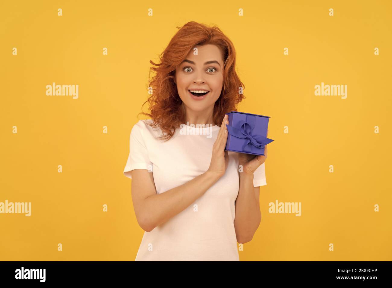 surprised lady with purchase box on yellow background, shopping Stock ...