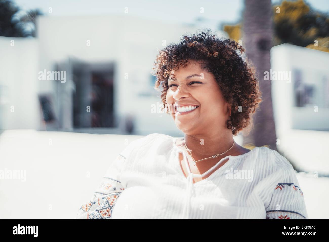 An outdoor portrait of a dazzling happy plus-size Hispanic female with ...