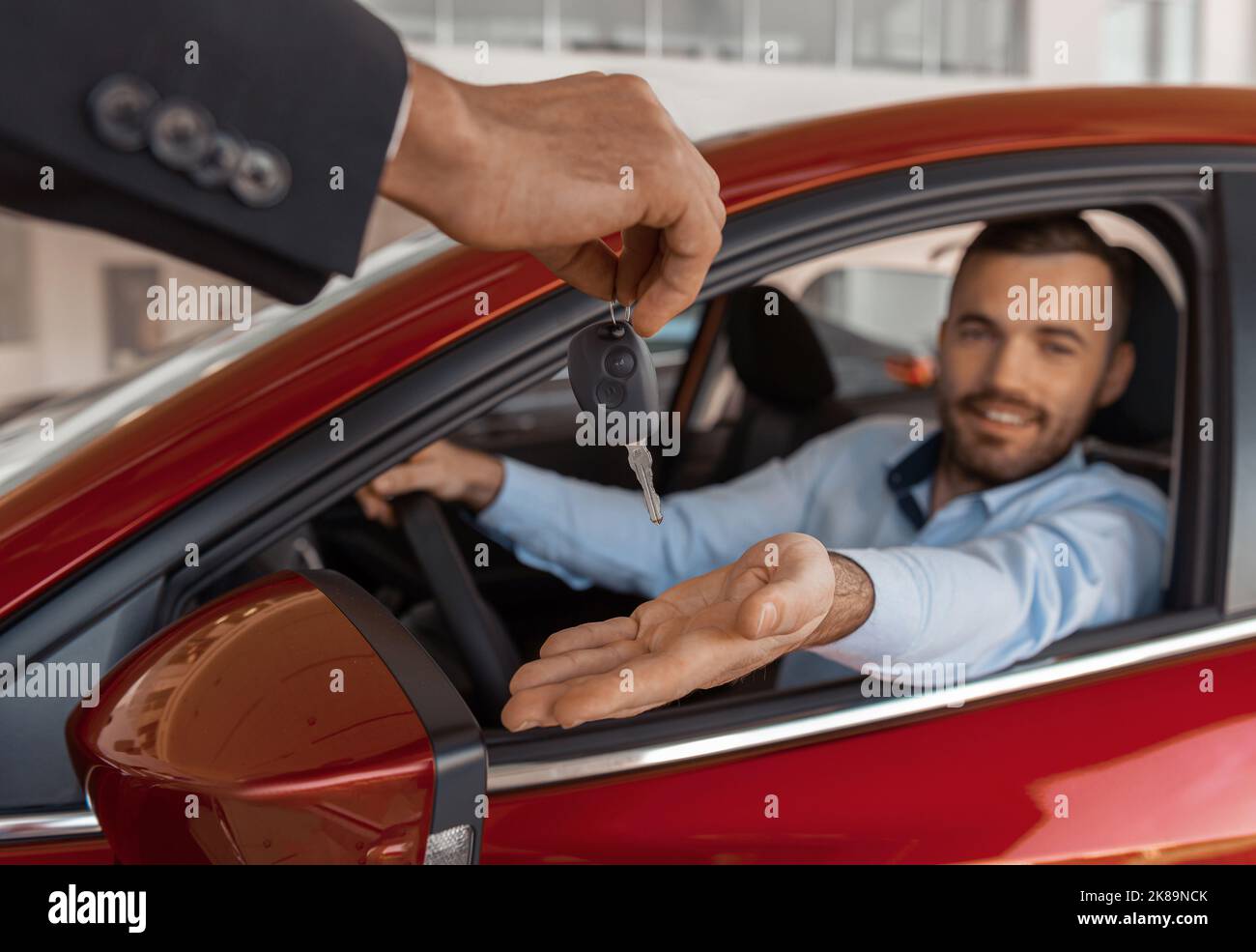 Young man sitting inside new car and getting keys to it. Concept for ...