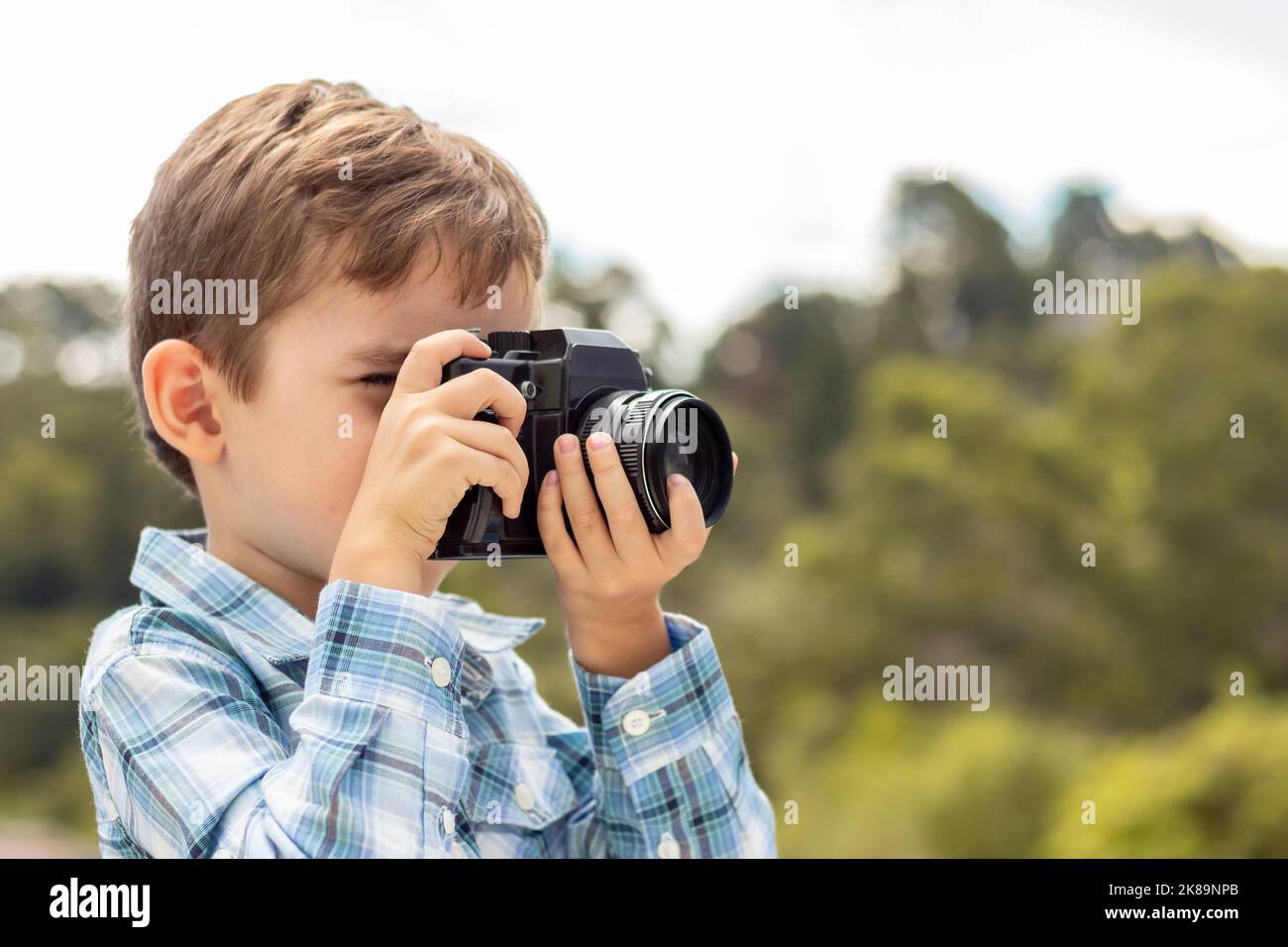Cheerful smiling child (boy) holding an instant camera Stock Photo - Alamy