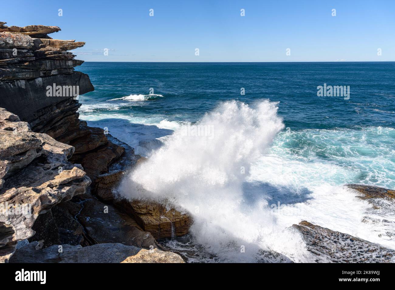 Waves crashing onto the rocks at the Shark Point cliffs in Clovelly ...