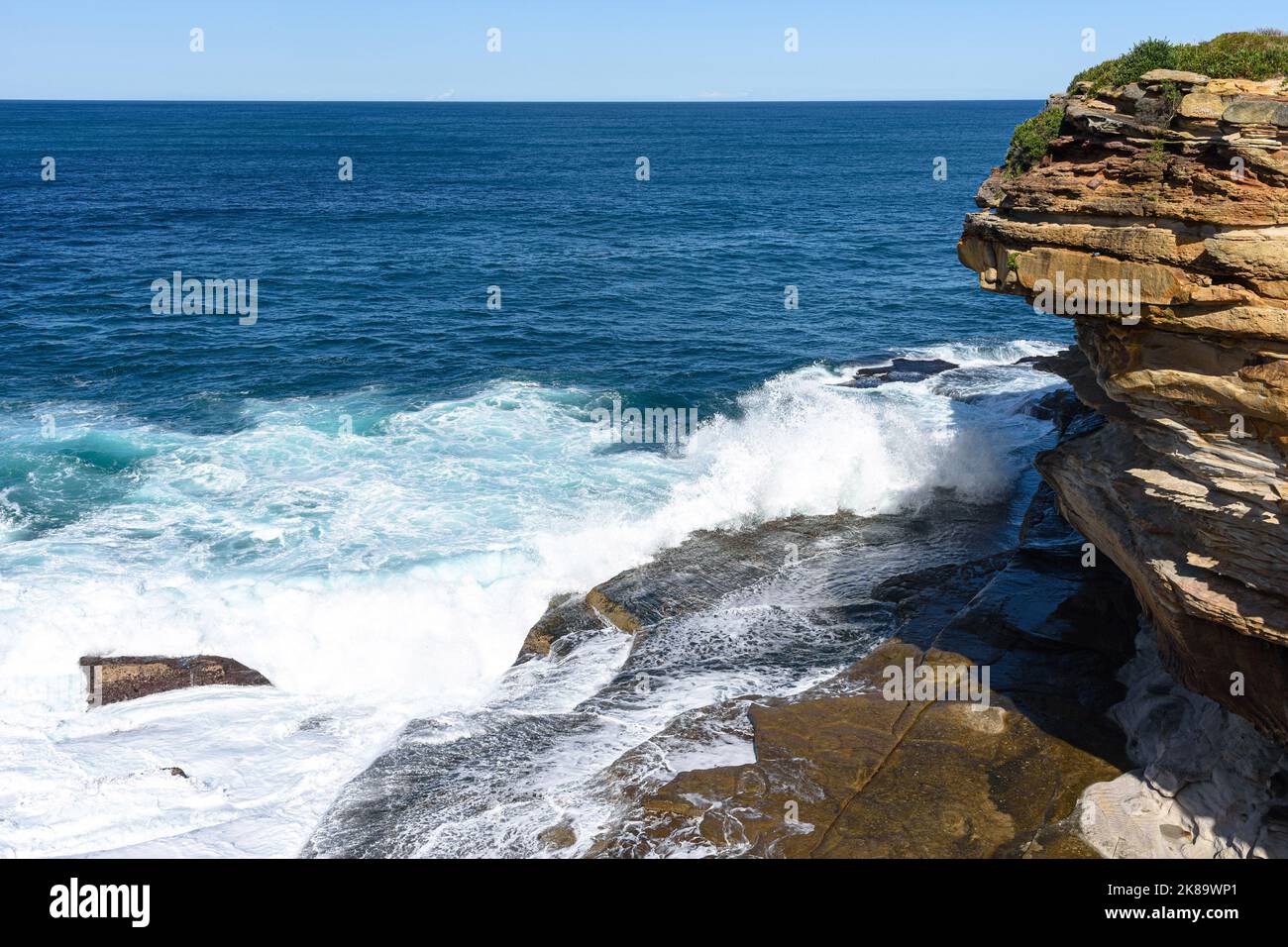 Waves crashing onto the rocks at the Shark Point cliffs in Clovelly ...