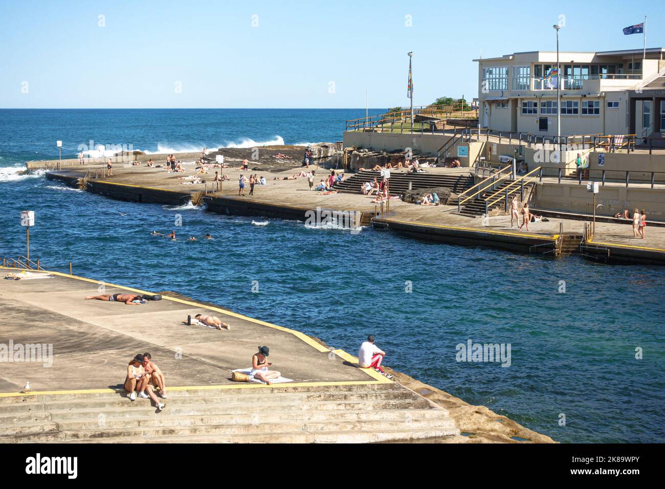 People sunbathing on the concrete at Clovelly Beach in Sydney ...