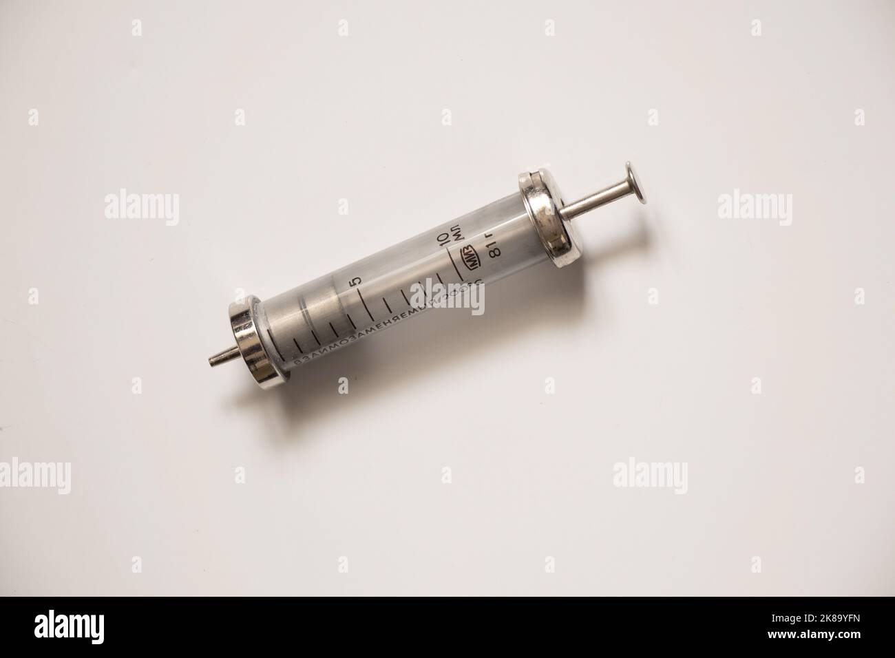 interchangeable old glass syringe on a white background, injections and ...