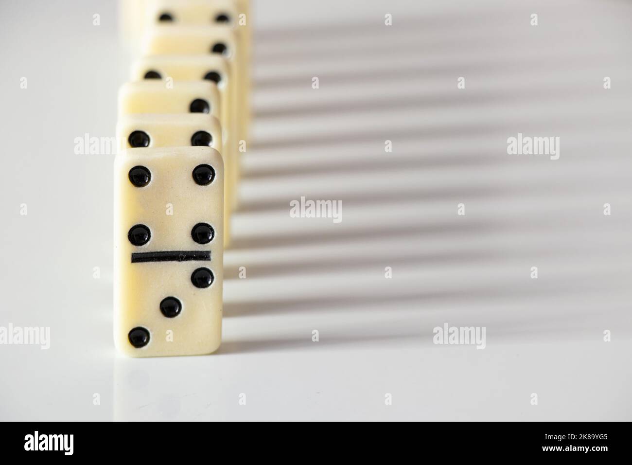 dominoes on a white background close-up, domino effect Stock Photo - Alamy