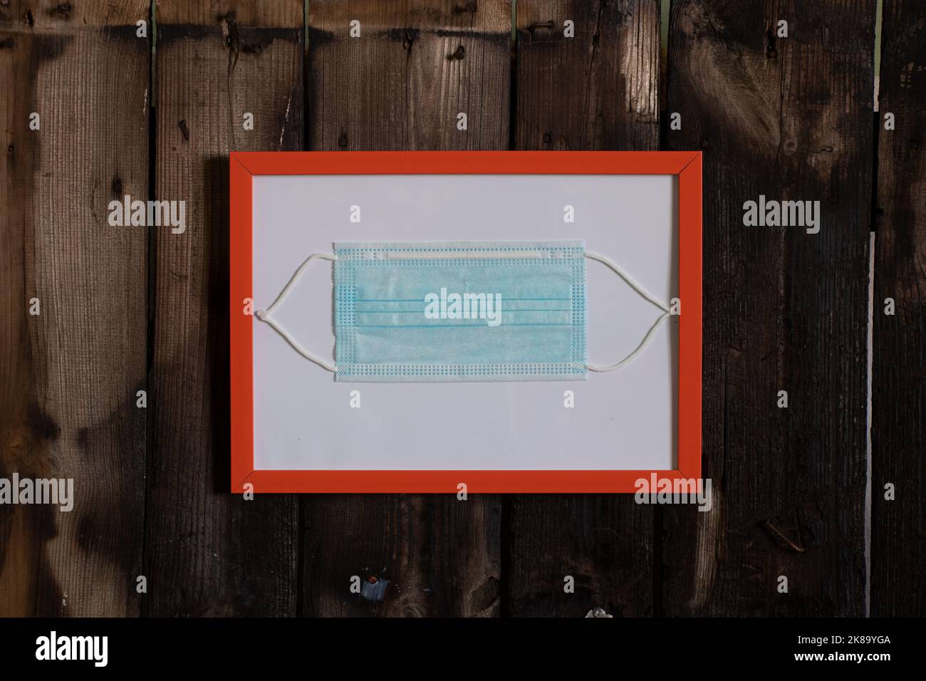 medical mask in a frame on an old wooden wall, a picture for the memory ...