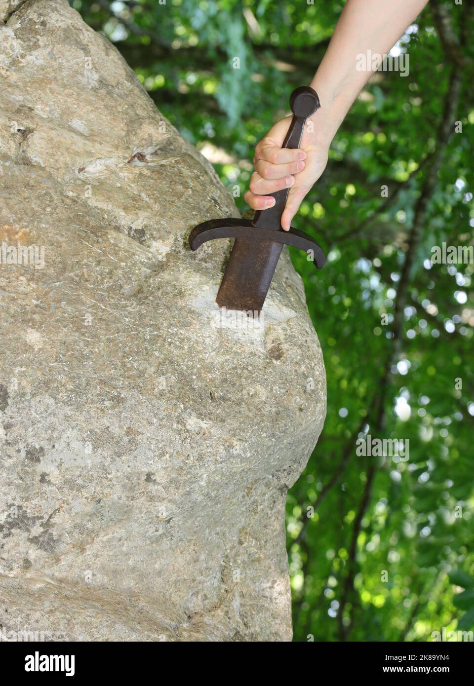 hand of the young man who forcibly tries to extract the sword Excalibur ...