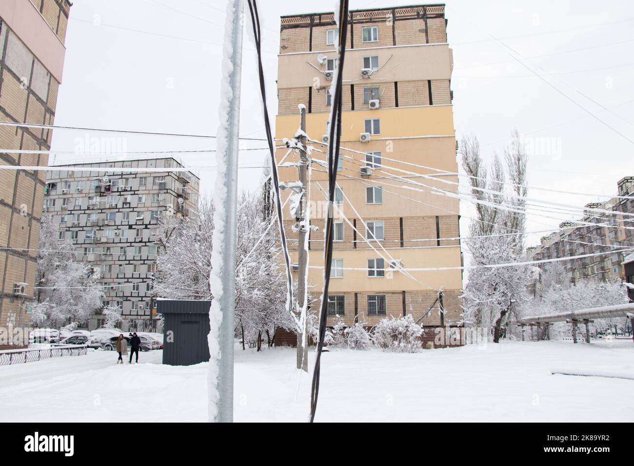 Electric wires in the snow with ice on a pole in a residential area of ...