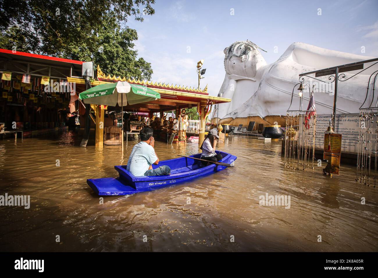 A tourist uses a boat to visit the reclining Buddha in the area of Wat ...