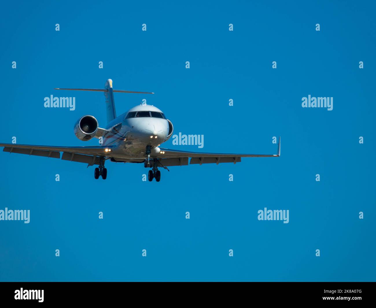 Private jet on approach for landing. Blue sky with plenty of space for ...