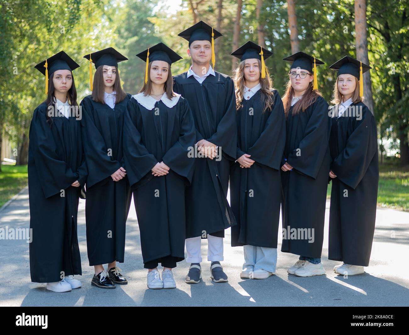 Seven graduates in robes stand in a row outdoors Stock Photo - Alamy