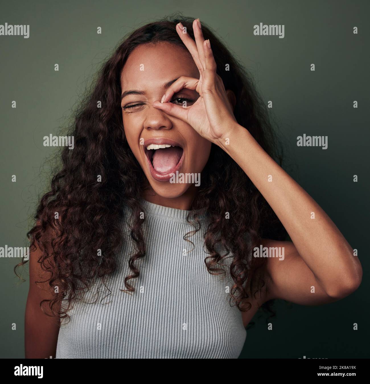 I spy with my beautiful eye. Studio shot of a young woman looking ...