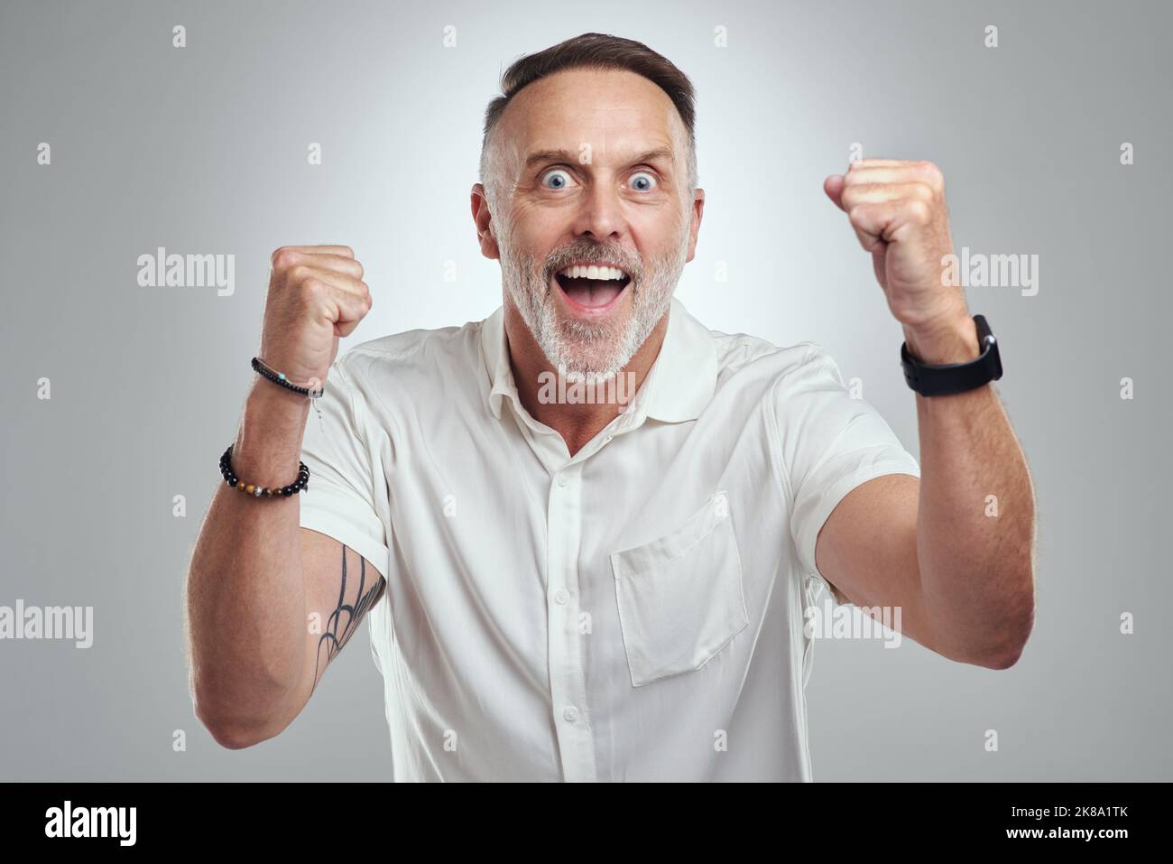 You did it. Studio portrait of a mature man cheering against a grey ...