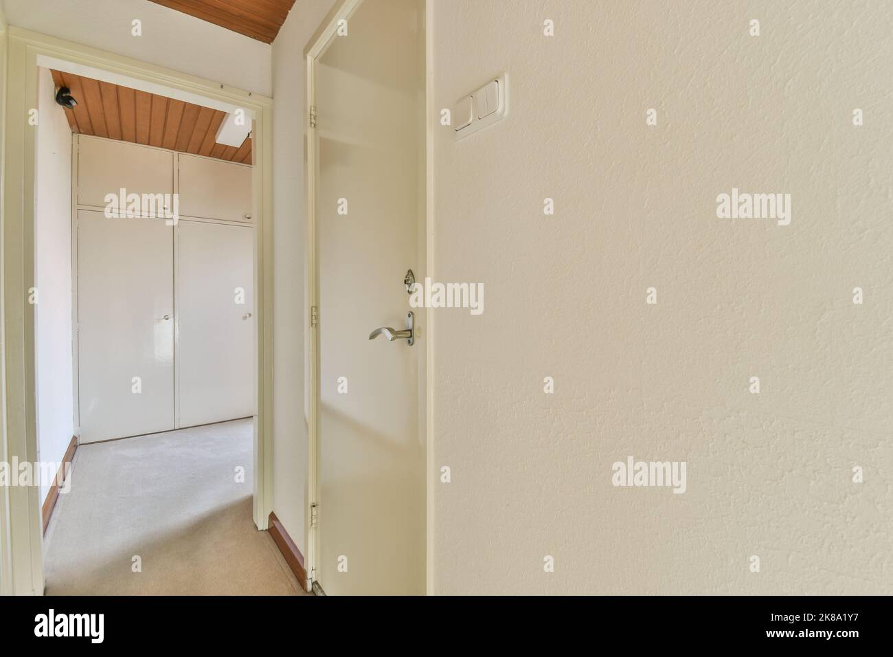 Light narrow hallway with many doors in white walls and glowing lamp ...