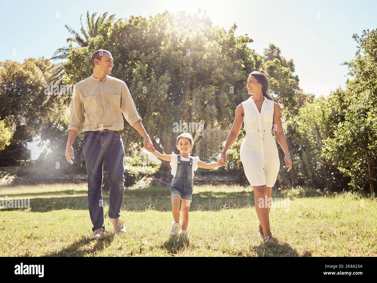 Portrait of happy family, park and walk holding hands bonding together ...