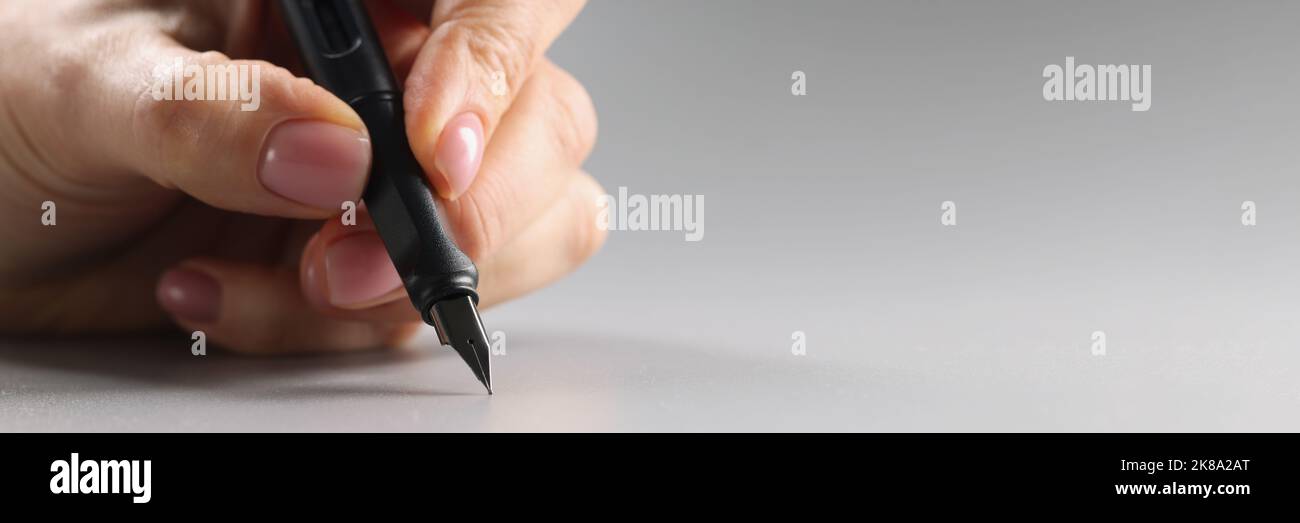 Person holding black feather pen, sharp tip, tool for writing Stock ...