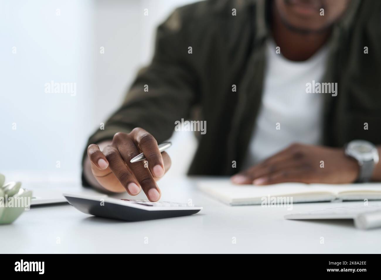 Running the numbers. a young man using a calculator at work Stock Photo ...