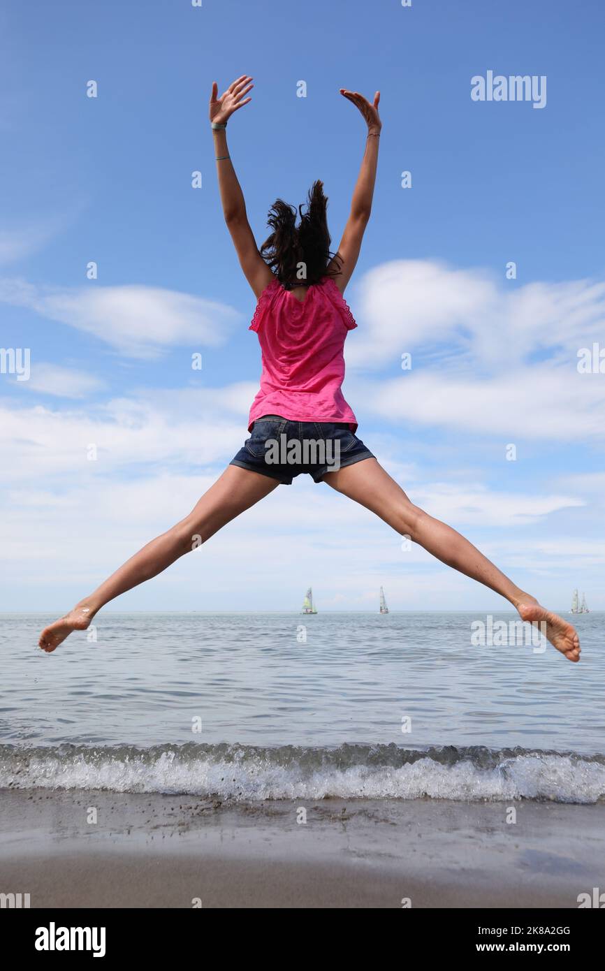 contented girl jumping and rejoicing happy by the sea in summer Stock ...