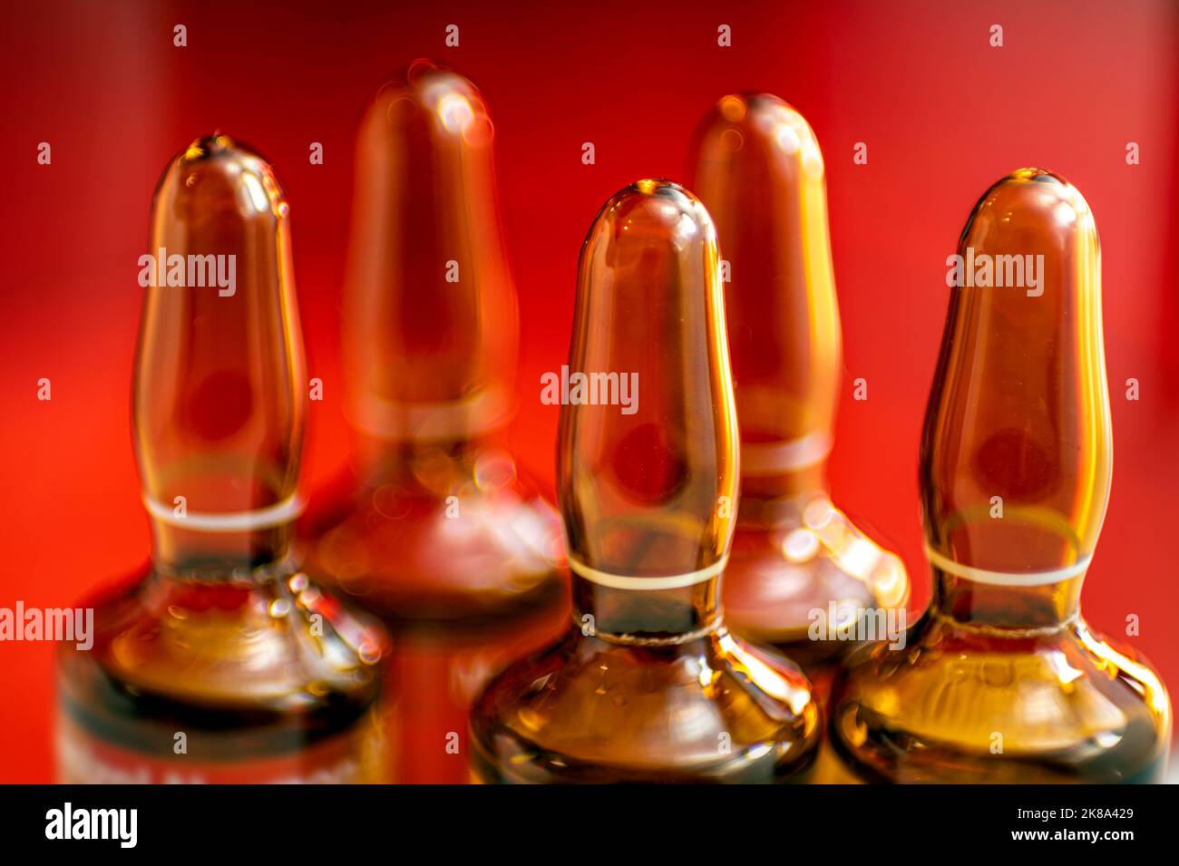 Still life of five brown injection medicine ampoules on a red ...