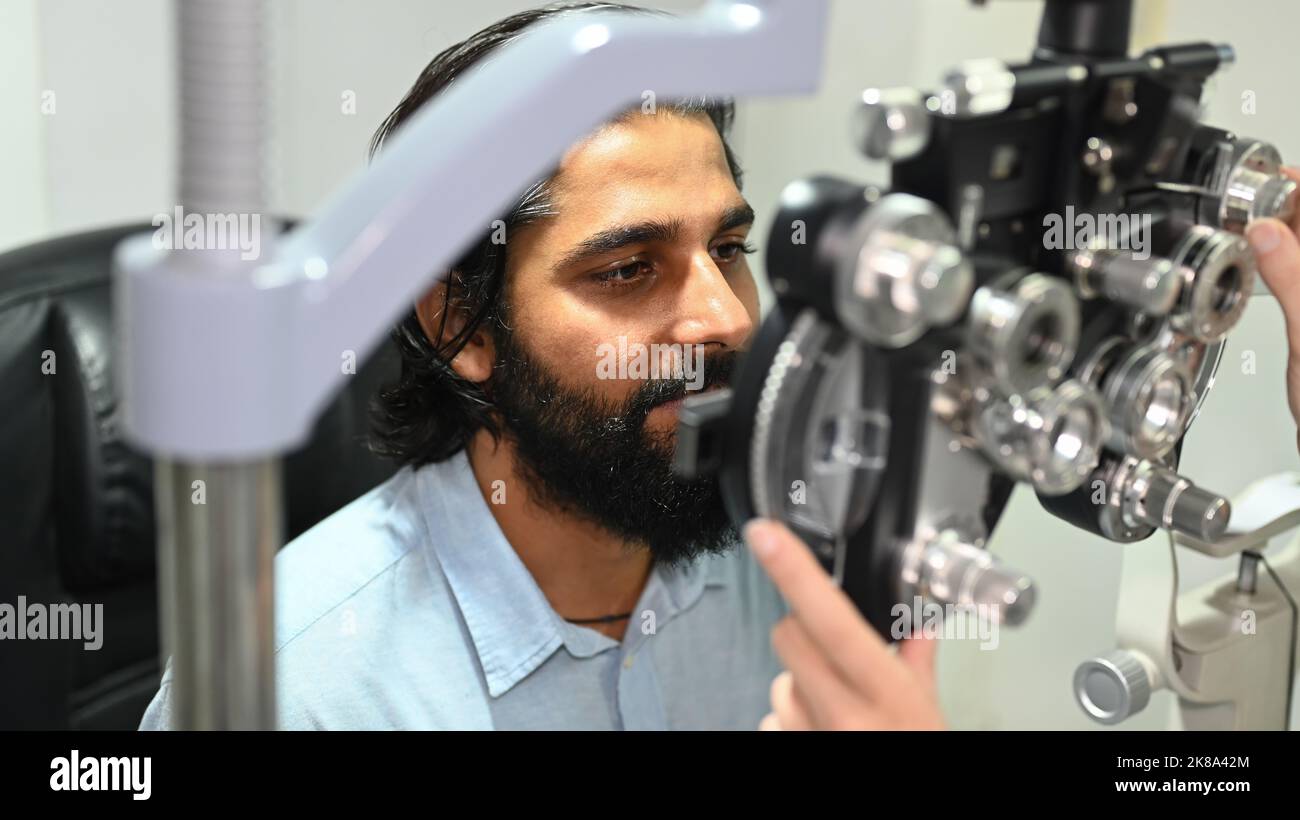Indian male patient checking eye vision with phoropter eyesight ...
