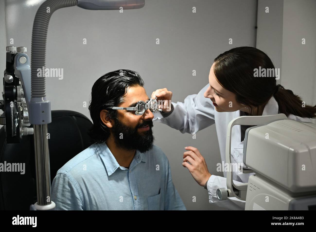 Optometrist doing sight testing for male patient with special ...