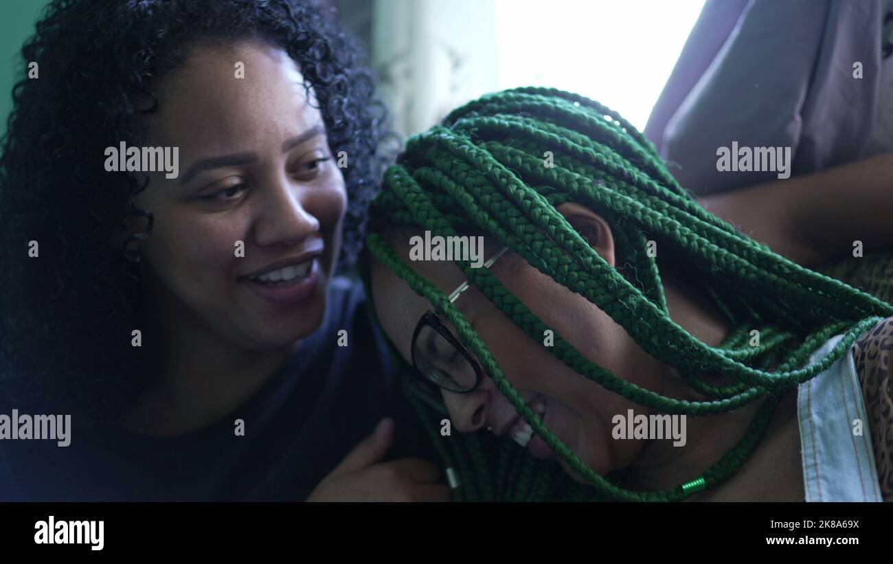 Candid female sisters at home in conversation. Two young hispanic black ...