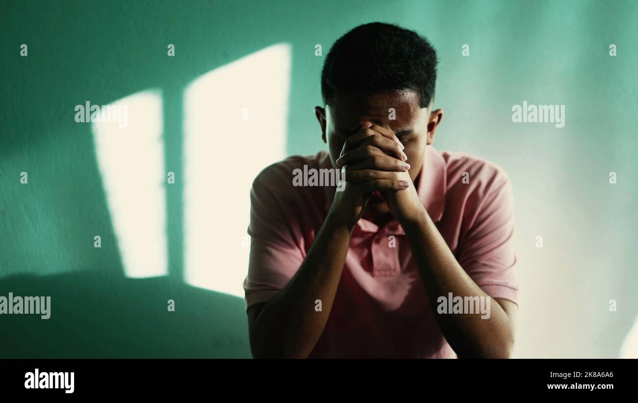 Dramatic young Brazilian man praying indoors having HOPE and FAITH ...