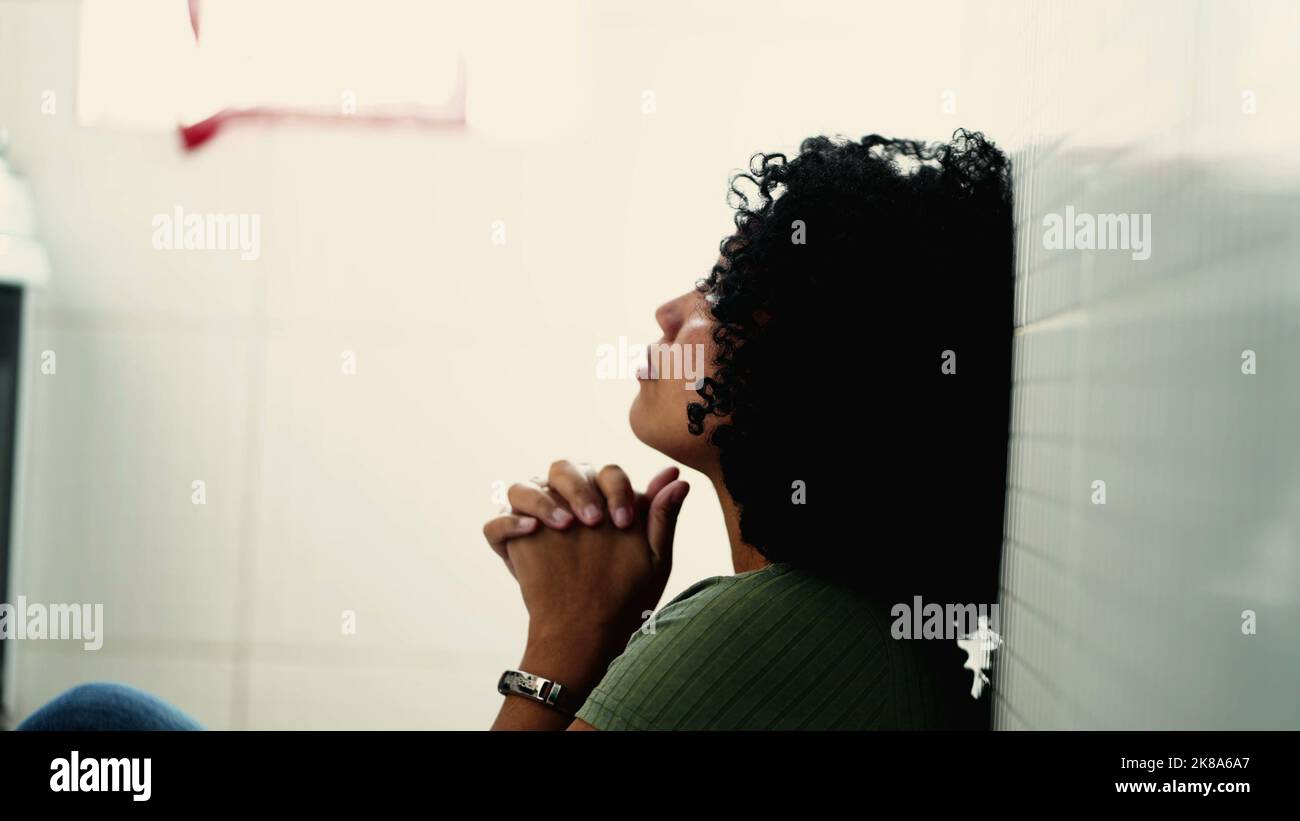 Faithful hispanic young woman praying to God during difficult times ...