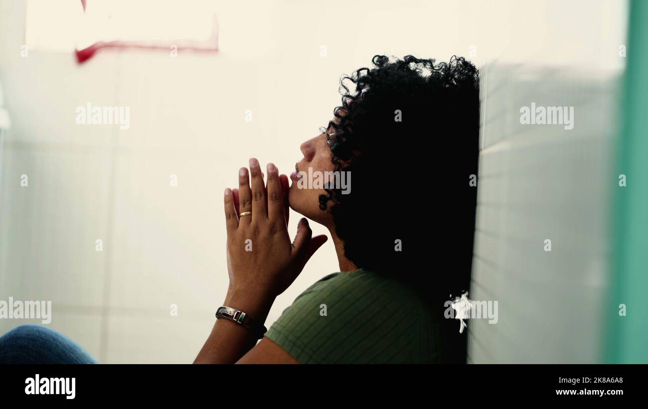 Faithful hispanic young woman praying to God during difficult times ...