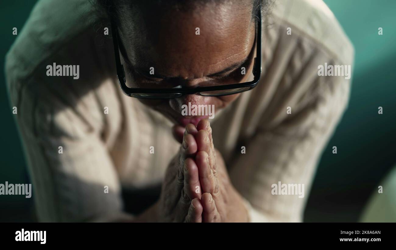 Faithful South American hispanic older woman praying to God at home ...