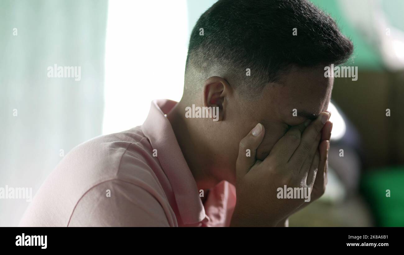 Desperate young man feeling hopeless and despair. A hispanic South ...