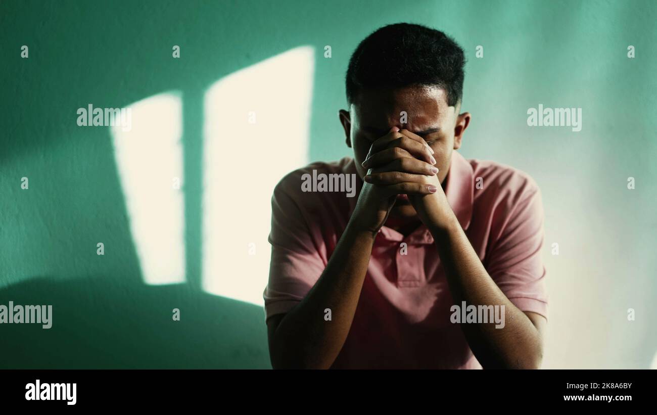 Dramatic young Brazilian man praying indoors having HOPE and FAITH ...