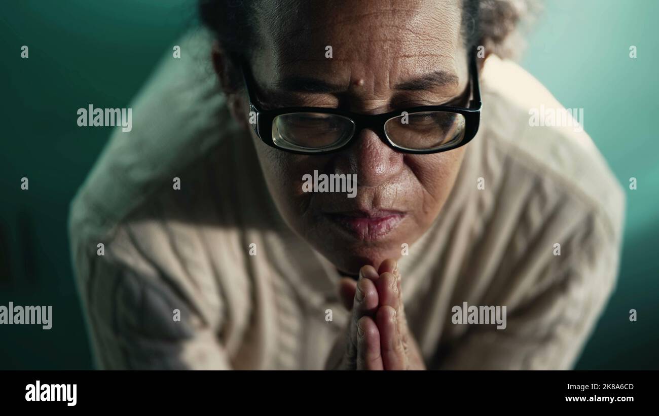 Faithful South American hispanic older woman praying to God at home ...