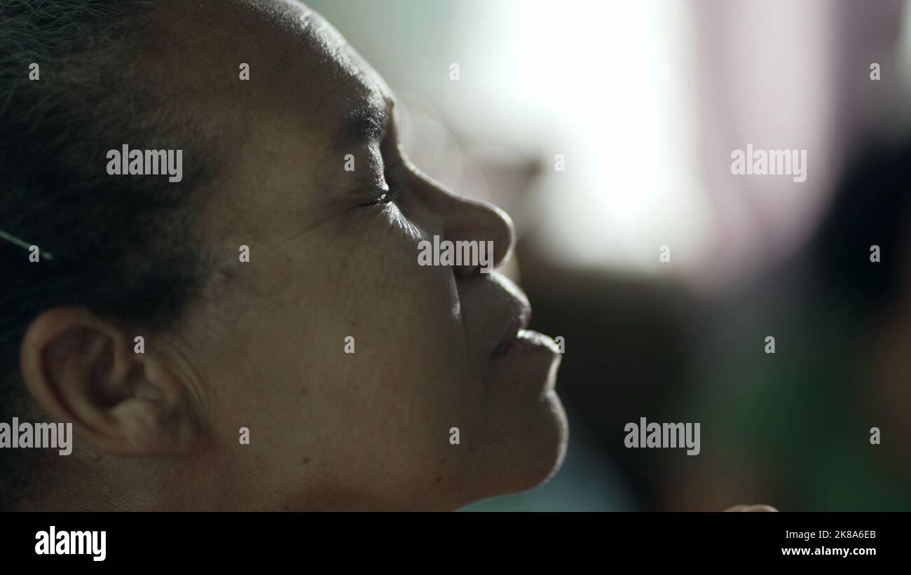 Meditative hispanic senior woman closing eyes in contemplation ...