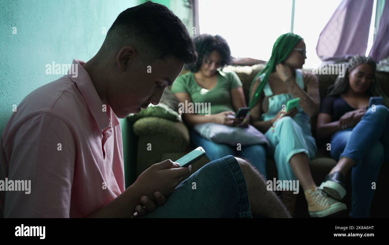 Group of hispanic people sitting on couch looking at smartphone device ...