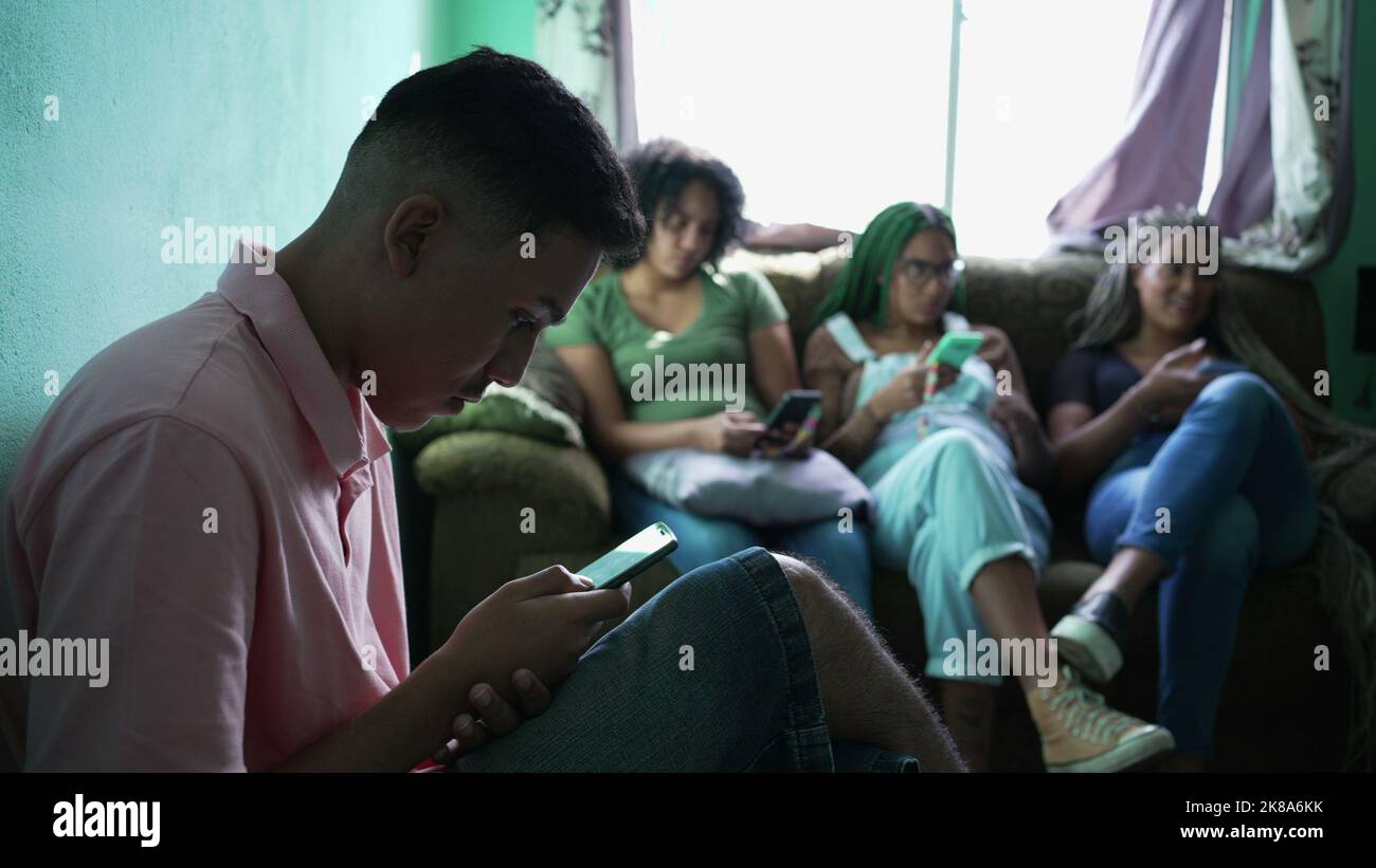 Group of hispanic people sitting on couch looking at smartphone device ...